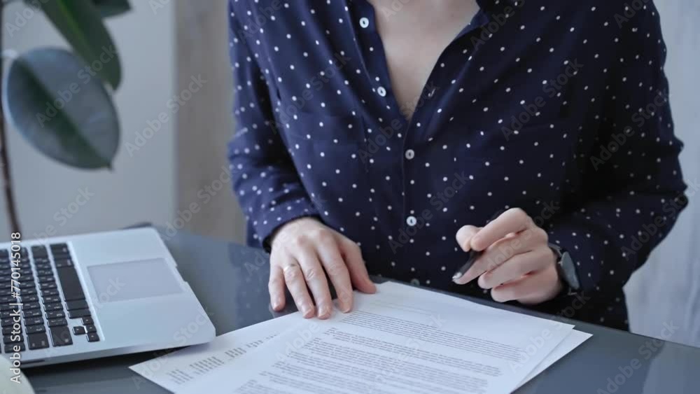 Unrecognizable business woman examining paperwork in an office setting ...