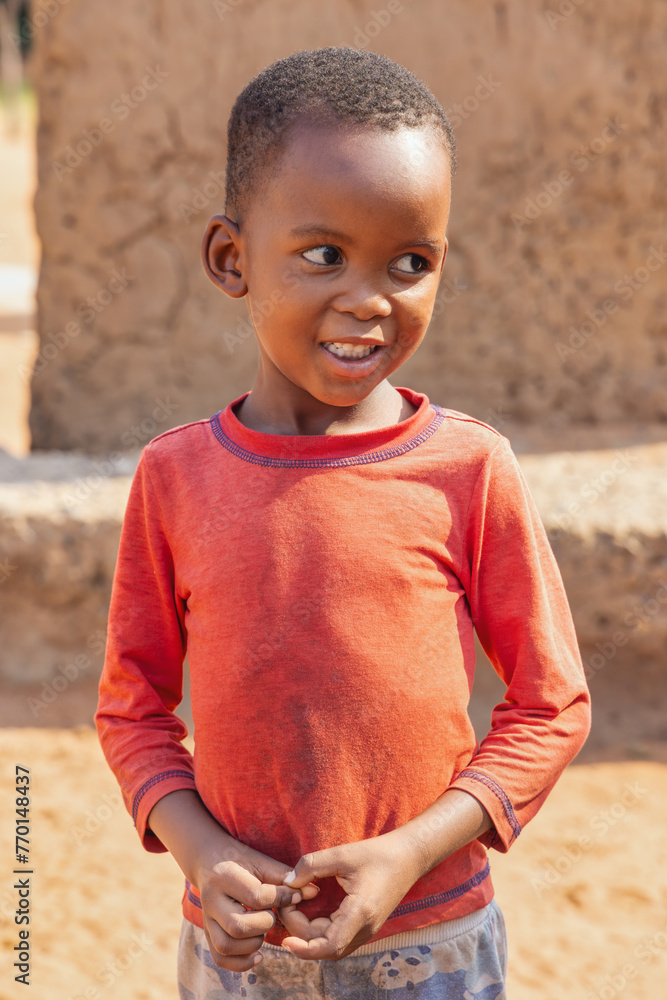 african child standing in front of the mud house, african village life ...