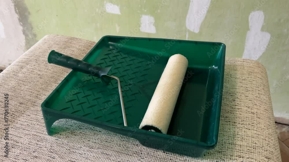 Paint roller in container room. Painting the walls in a room with a ...