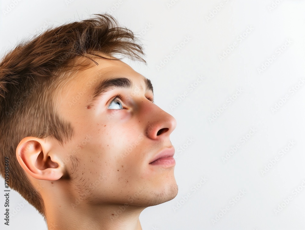 Young man looking up on white background, closeup portrait of face with ...