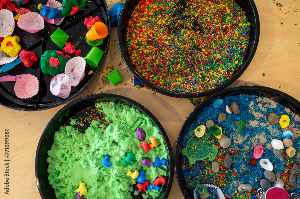 Sensory play bins, each filled with different colorful materials to ...