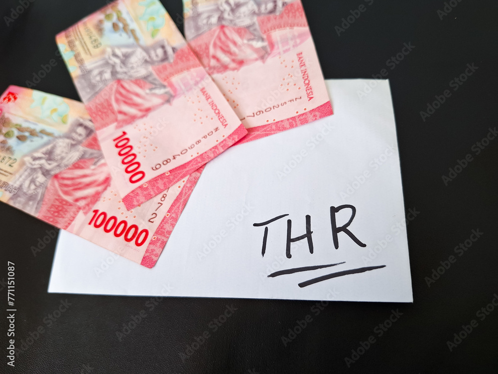 Envelope and three hundred thousand rupiah in cash. THR (Tunjangan Hari ...