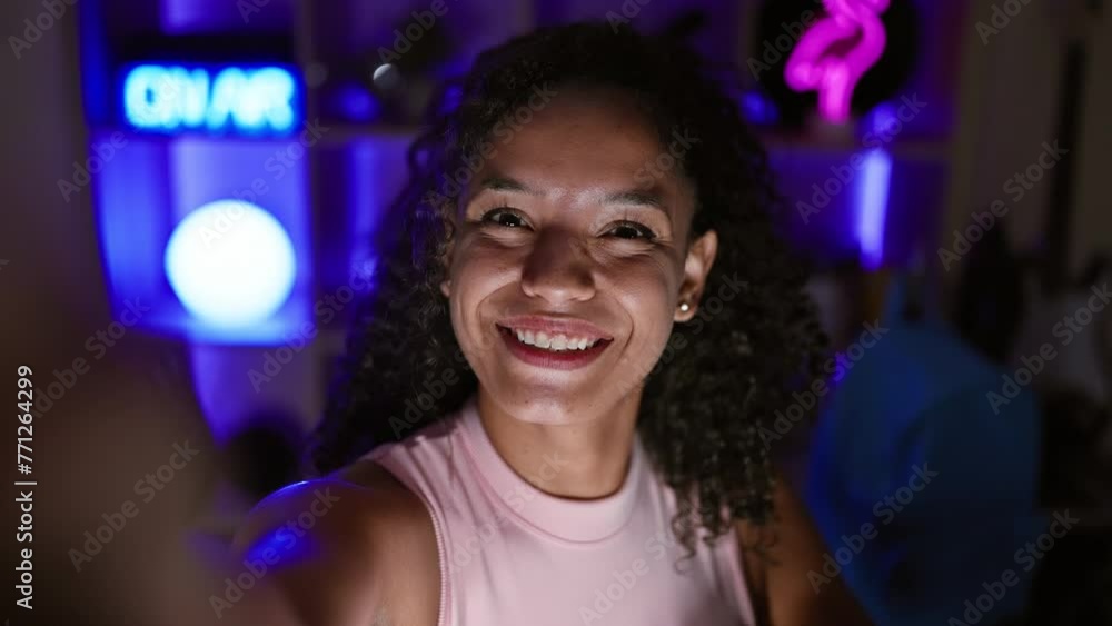 Confident curly-haired young hispanic woman streamer rocks her gaming ...