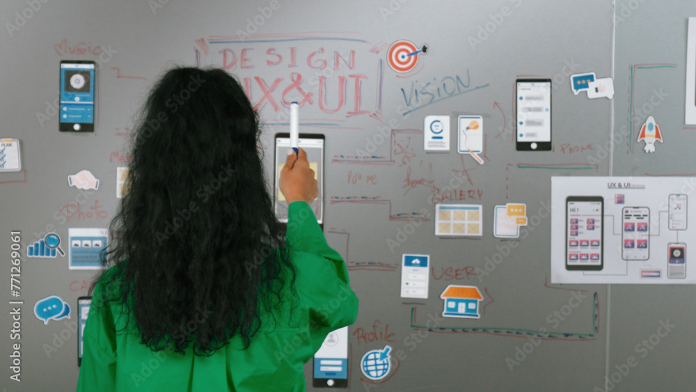 Young hispanic businesswoman writing Ux and Ui design on board ...