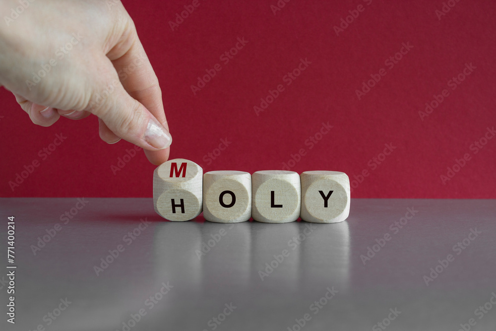 Hand turns a cube and changes the word Holy to Moly. Beautiful green ...