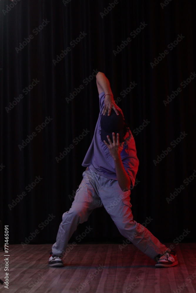 An Indian Hip Hop Dancer Boy Wearing over sized T-Shirt and loose jeans, dancing and posing in ...