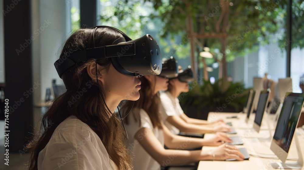 Individuals seated at desks wearing virtual reality headsets, immersed ...