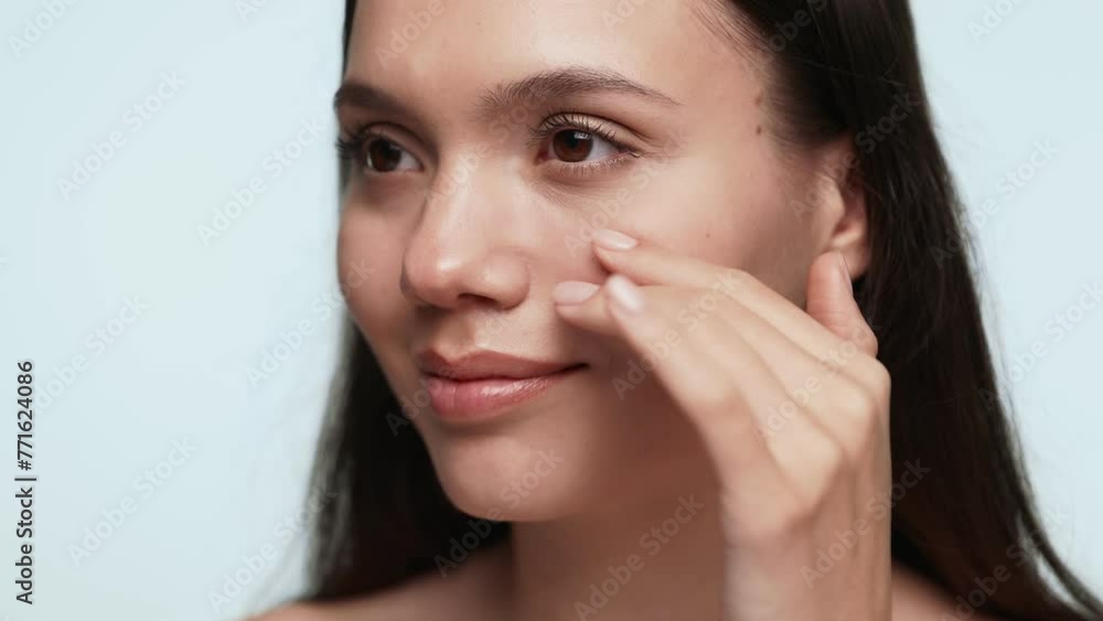 A detailed close-up capturing a woman's hand gently touching her face ...