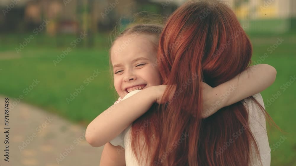 Little daughter, baby hugging mom on street. Child mother outdoor. Mom child hugging in park in ...