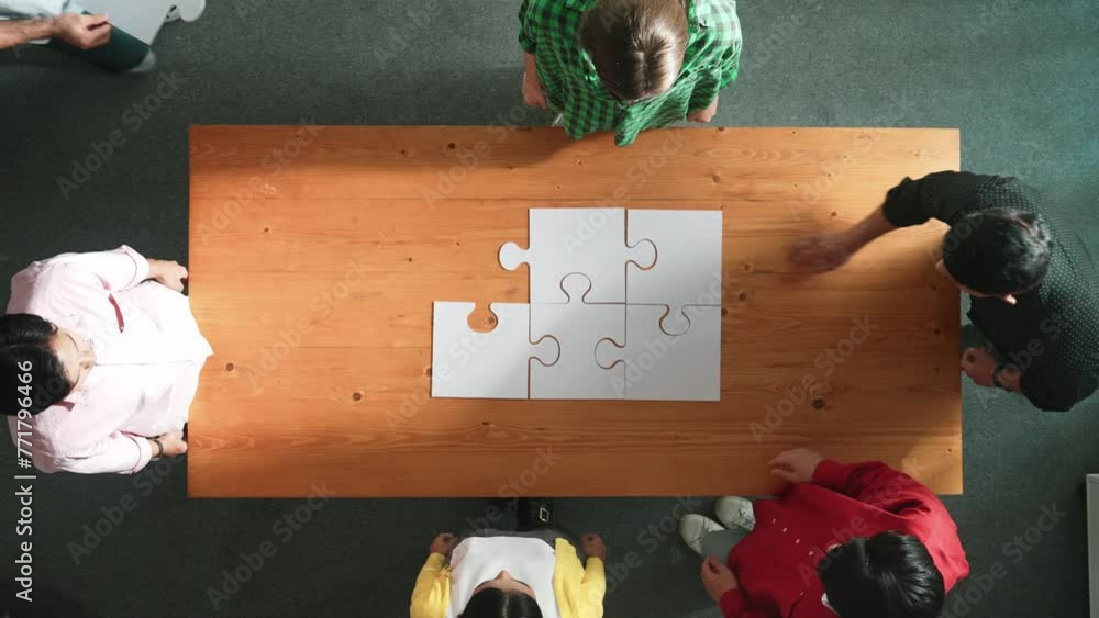 Top view of business man gathering last piece of jigsaw to complete ...