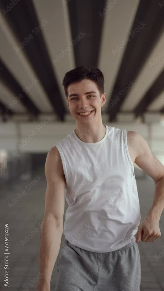 Vertical video. Street dance performed by a smiling guy. The young man ...
