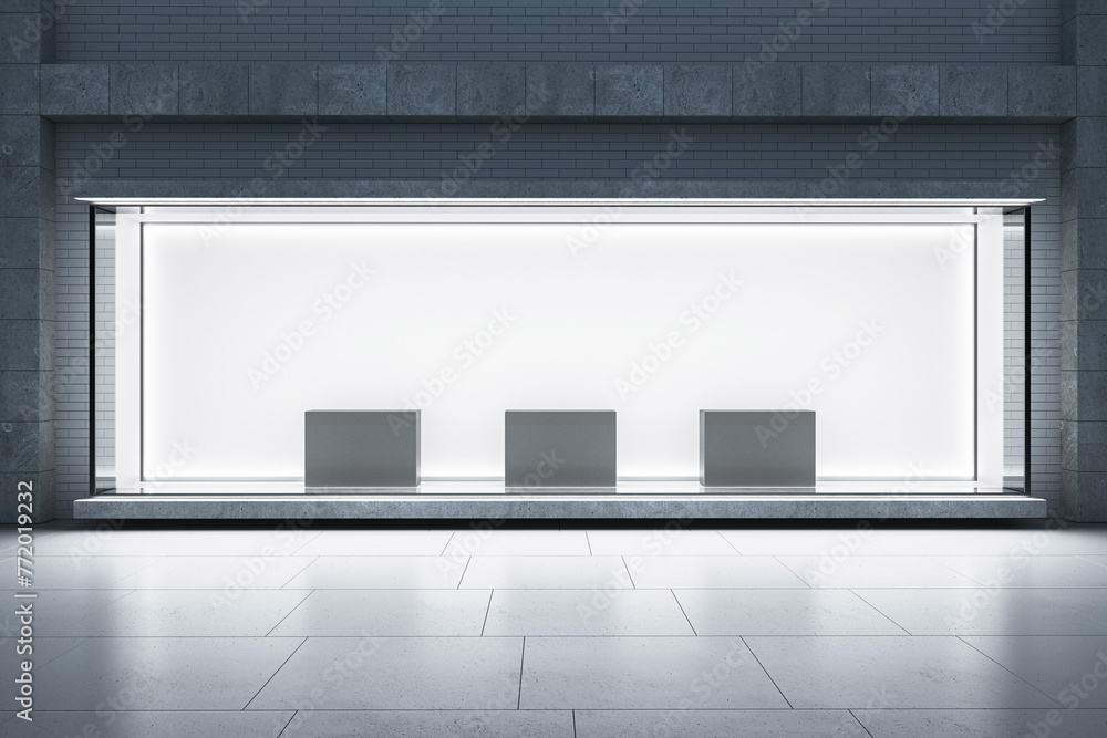 An empty storefront with a large window display, backlit glass, and ...