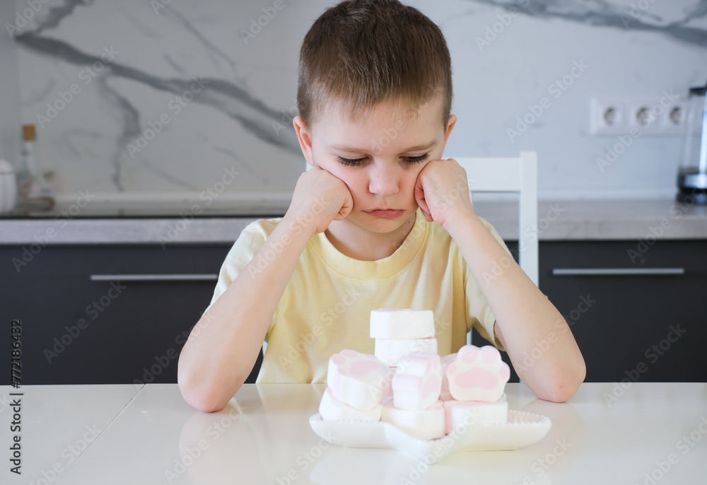 Child has toothache when eating sweets. Boy holds his hand to his cheek ...