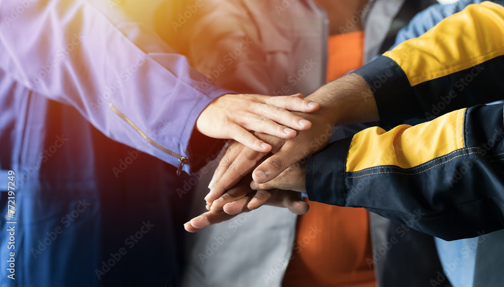 Group of male and female factory workers standing putting their hands ...