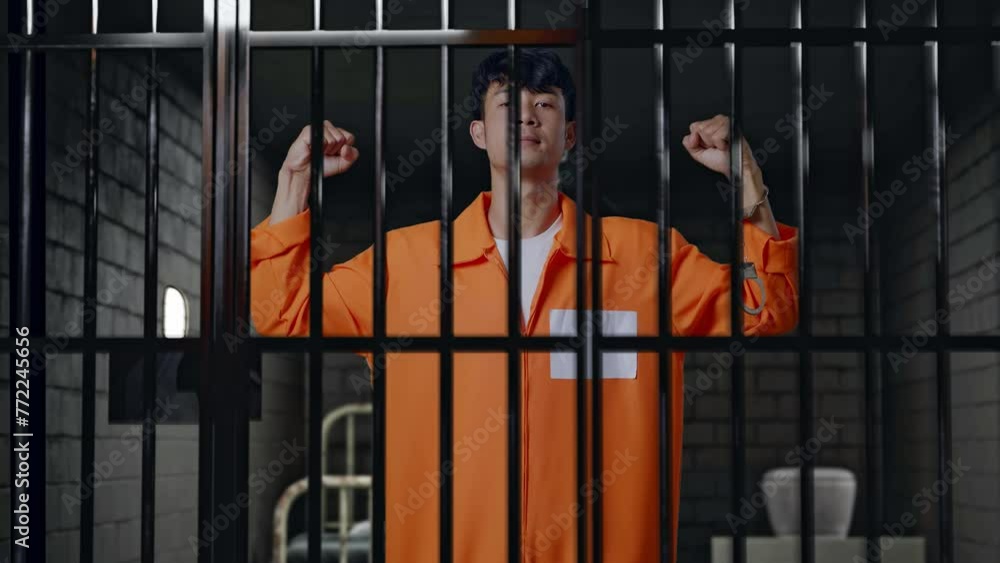Asian Male Prisoner With Broken Handcuffs Flexing His Bicep While ...