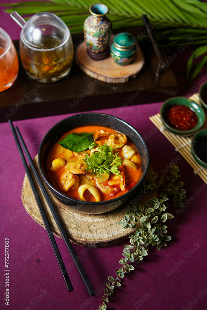 tom yum, soup, in a black bowl, top view, shrimp, mushroom, squid, red ...