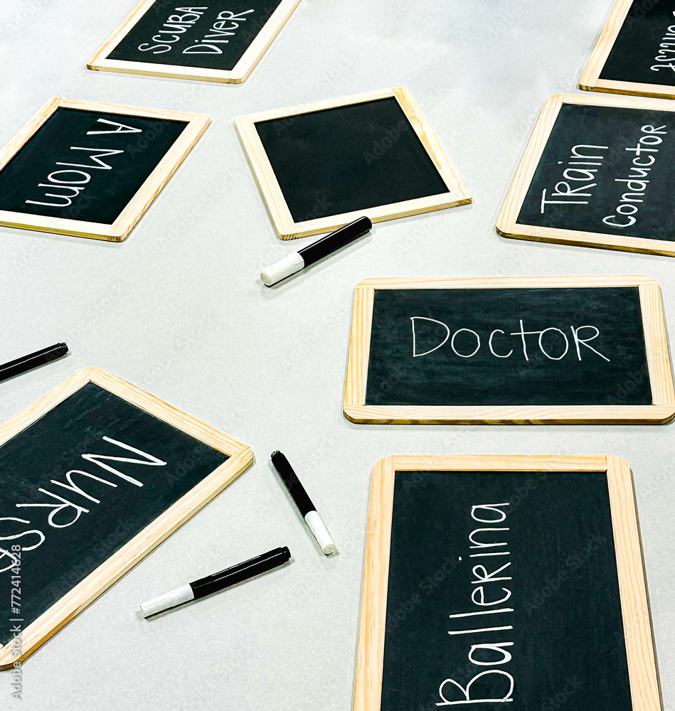 Group of occupation words written on a black chalkboard flat lays on ...