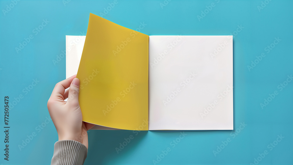 Hand holding blank brochure booklet or book mockup on blue background ...
