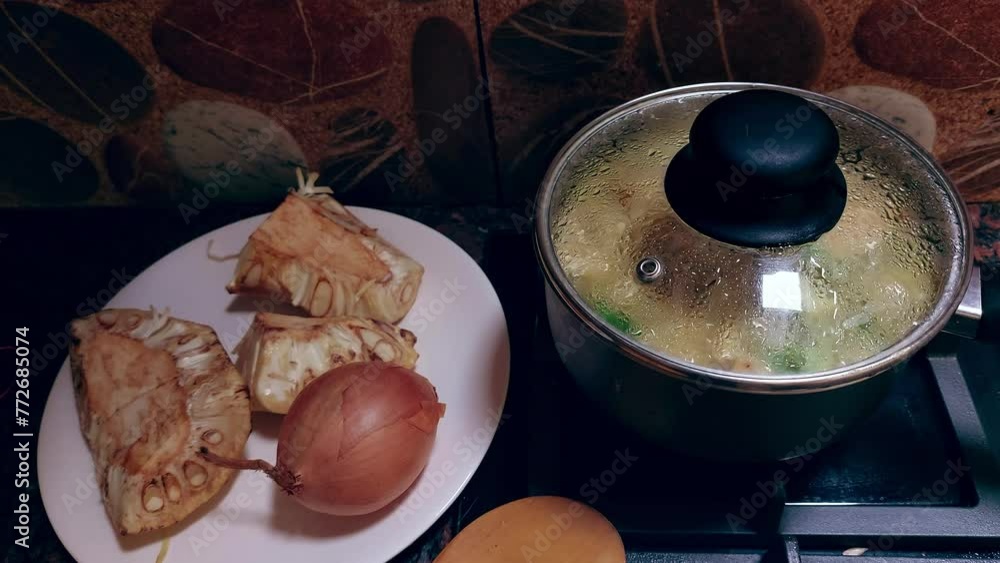 Cooking pot of simmering ginataang langka on a stove with glass lid ...