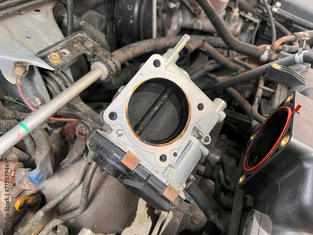 carbon deposits damage a throttle valve of a car engine. The valve ...