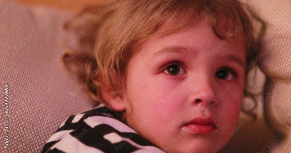 Child watching TV screen, close-up of toddler face hypnotized by ...