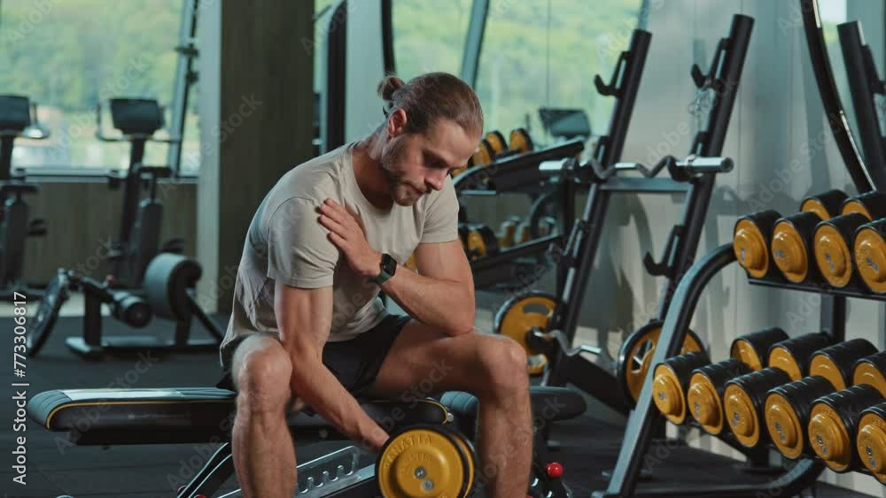 Vidéo Stock Focused young man sitting on bench press and doing triceps ...