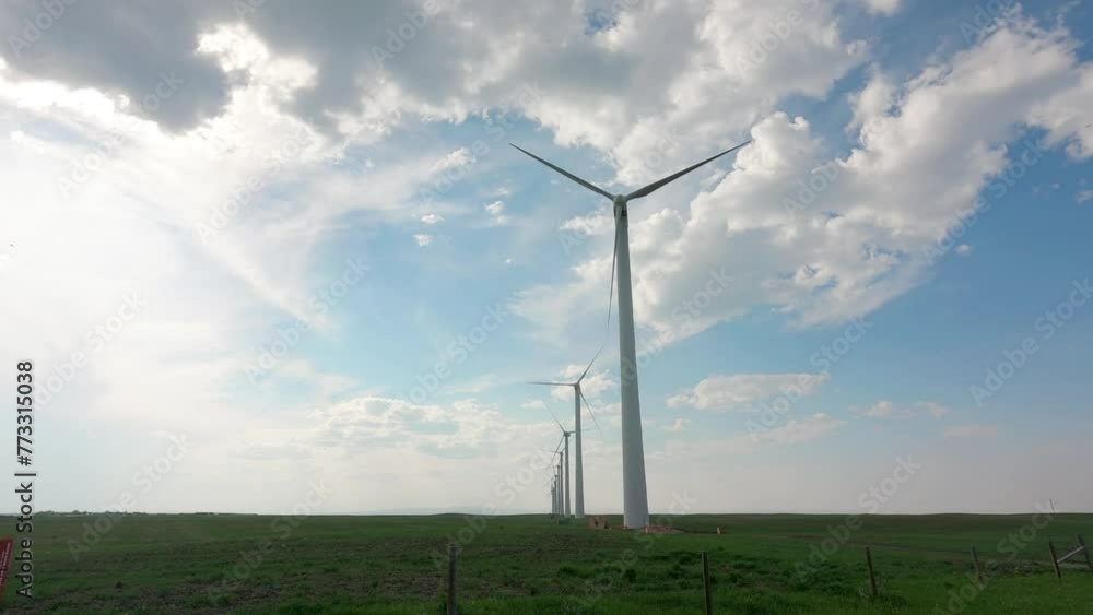 driving alone wind turbines line up on the green field with heavenly ...