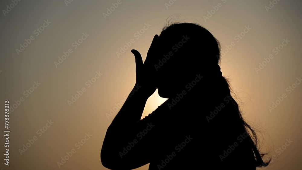 A woman stands exhausted under the hot sun and wipes the sweat from her ...