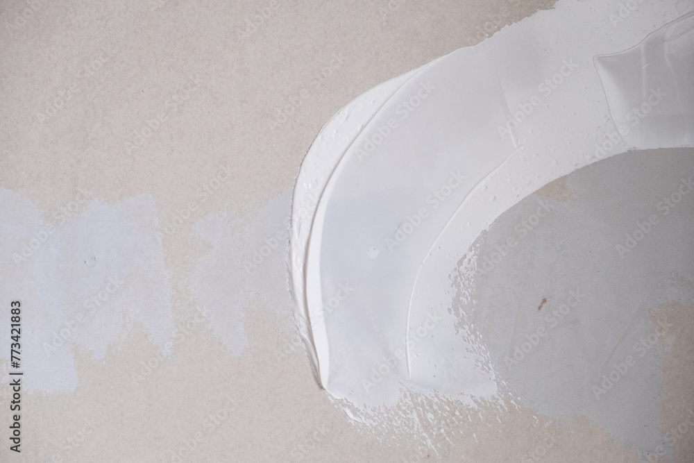 Applying decorative putty. White abstract texture of surface covered ...