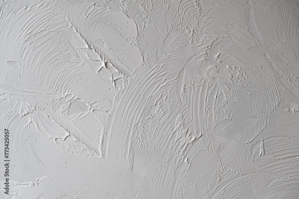 Applying decorative putty. White abstract texture of surface covered ...