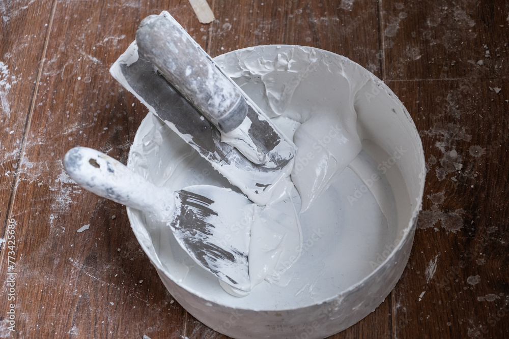 Applying decorative putty. White abstract texture of surface covered ...