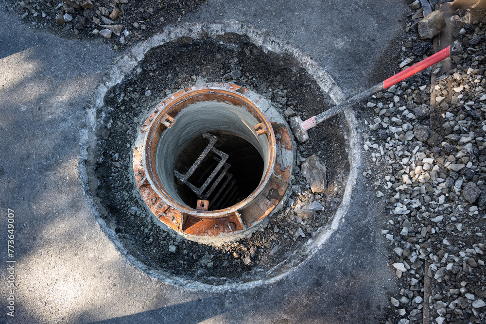 Foto de Open sewar access manhole in road repaving project, from above ...