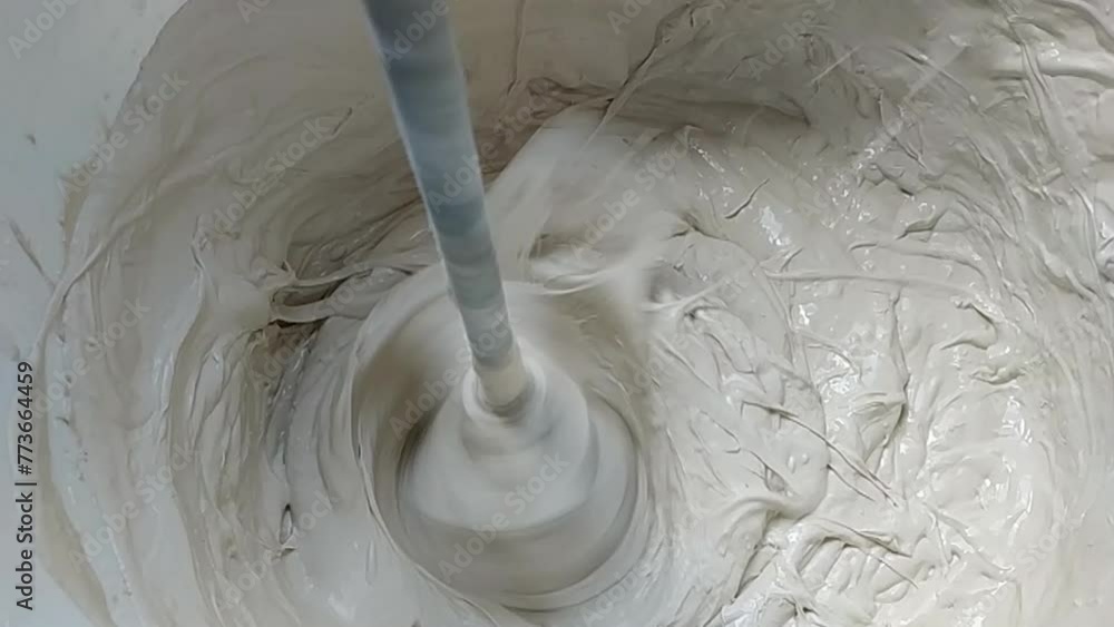 Vidéo Stock Mixing gypsum putty or white plaster using a electric ...
