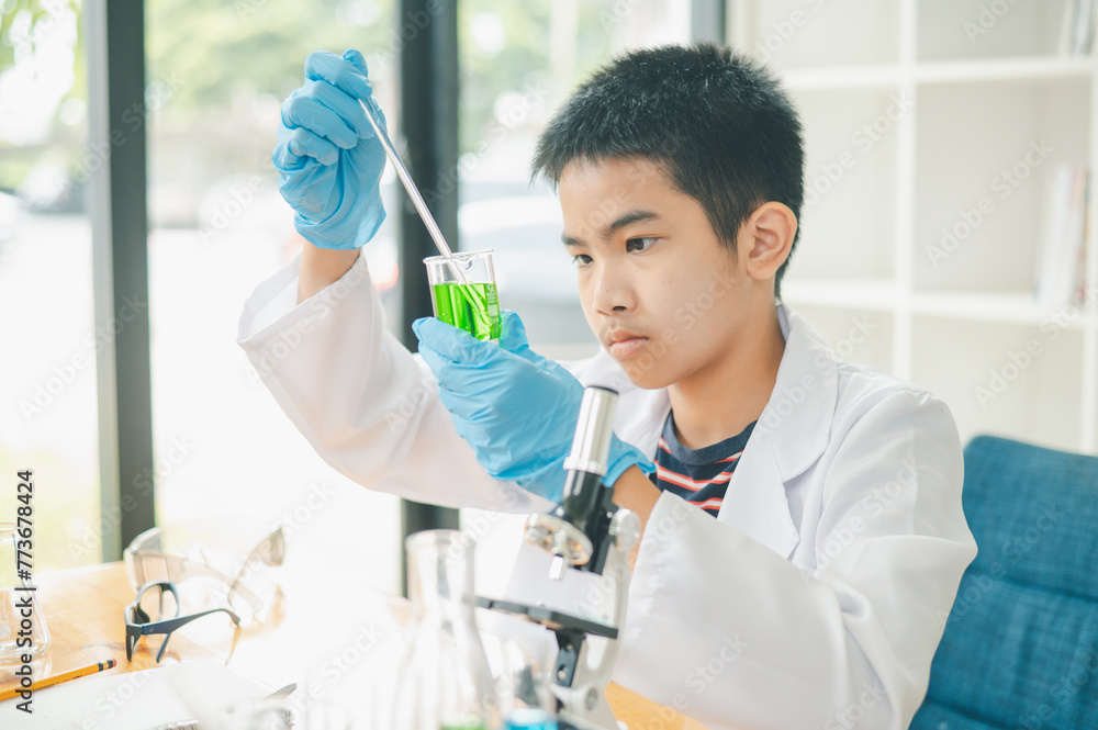 Asian male science students looking through a microscope and tests of ...