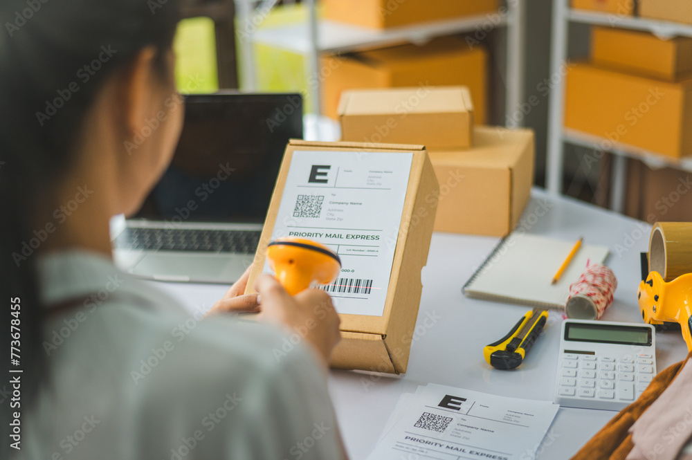 online small business owner scans a barcode-labeled parcel with a ...