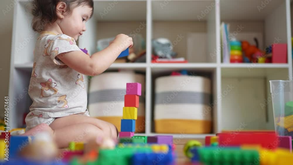 baby plays with toy blocks on the floor. development of fine motor ...