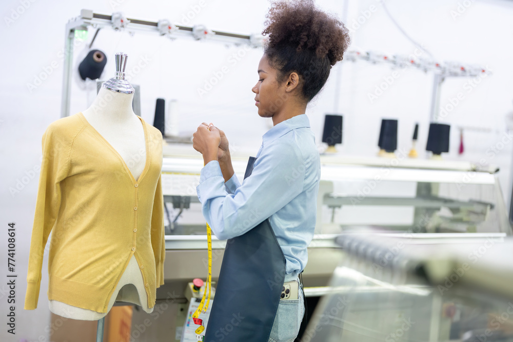 American female designer and seamstress looking at and designing ...