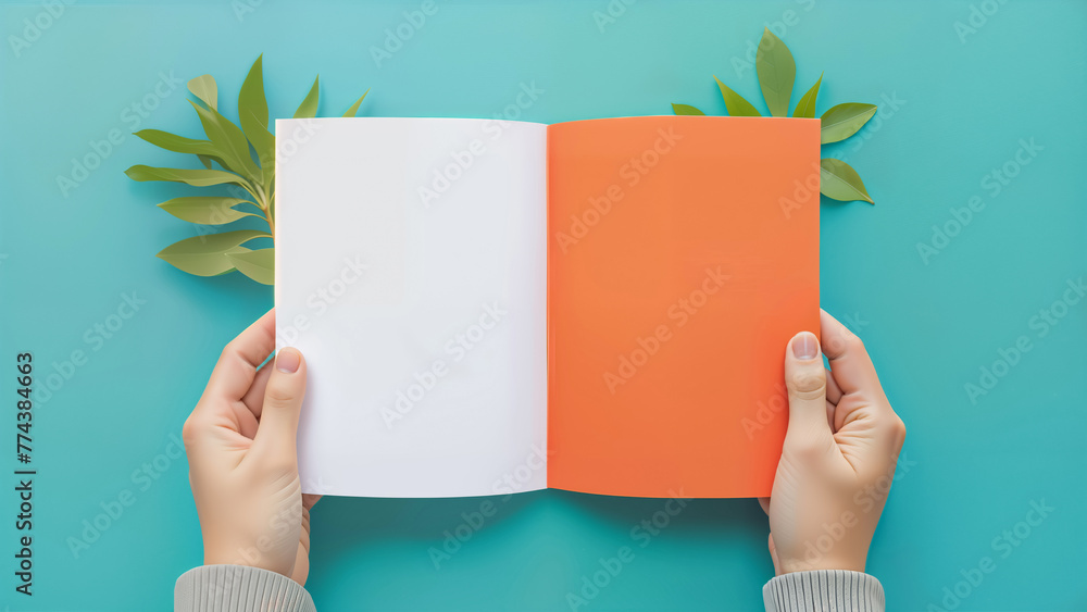 Hand holding blank brochure booklet or book mockup on blue background ...