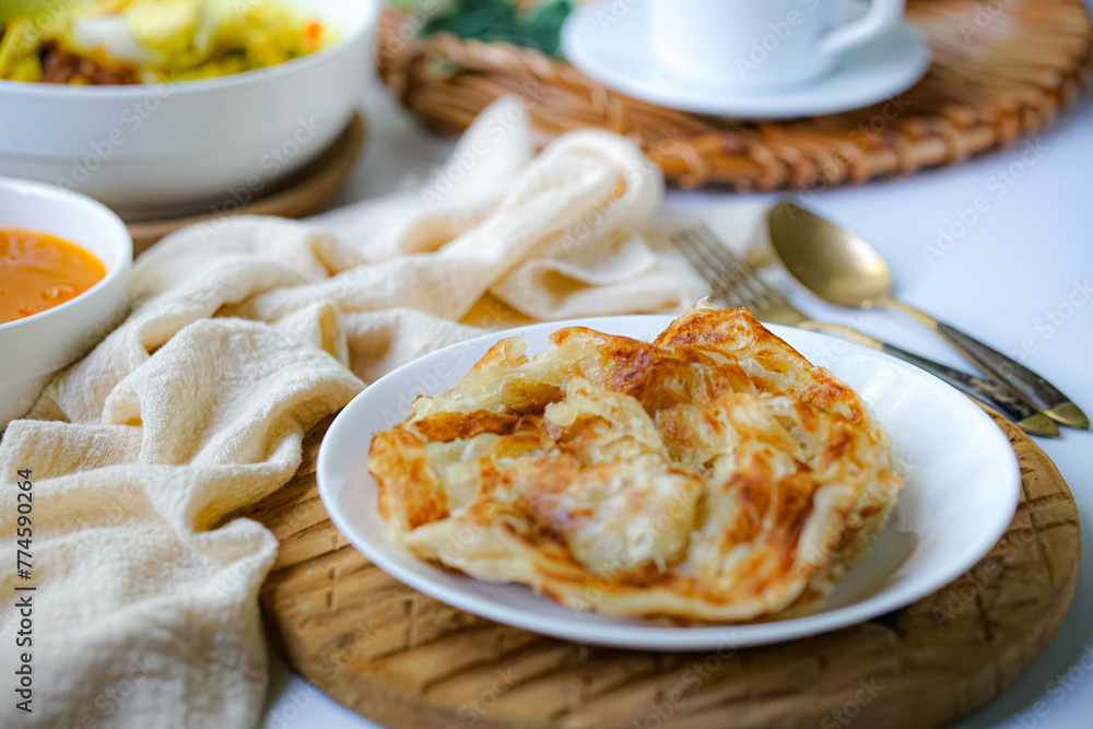 Roti Parata or Roti canai with curry sauce, a popular Malaysian ...
