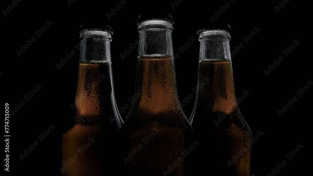 Coke bottles showcased against a black backdrop illuminated and ...