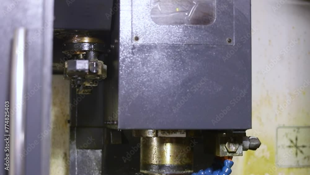high precision CNC turning machine throwing coolant liquid on metal ...