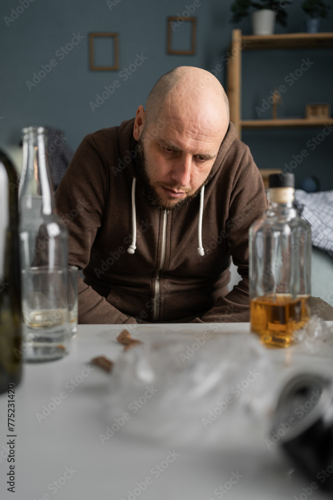 Drunken man with empty alcohol bottles at home. Depression, alcohol ...