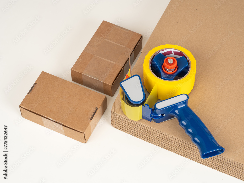 Packing tape dispenser. Small cardboard boxes. Packing materials ...
