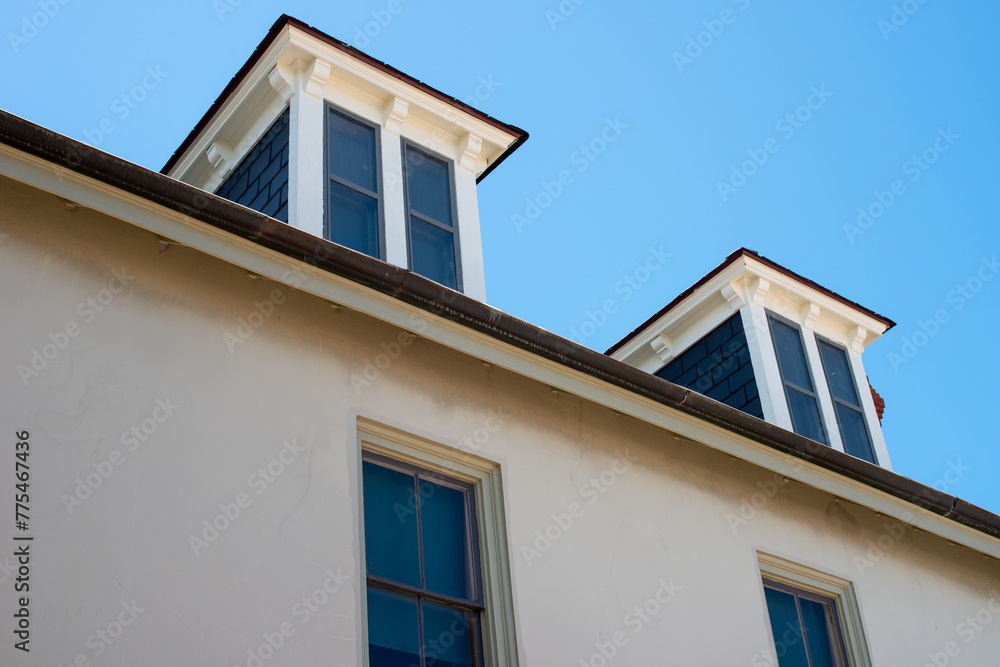 Two dormer windows with two double hung windows per dormer. The ...