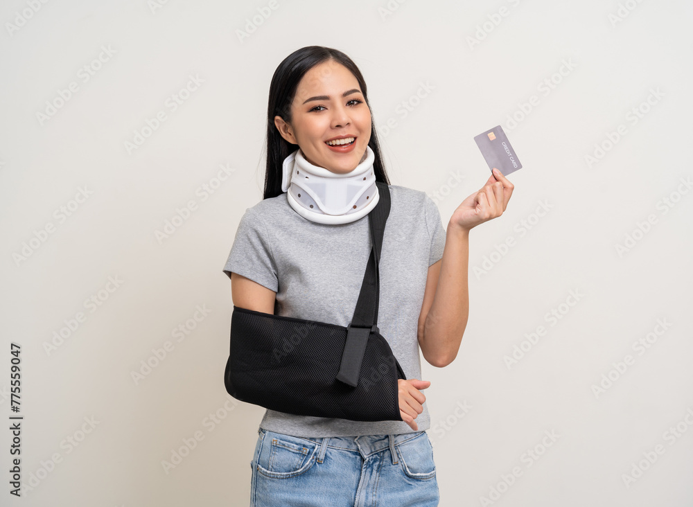 Asian woman broken arm and leg holding credit card payment. Woman put on plaster cast splint ...