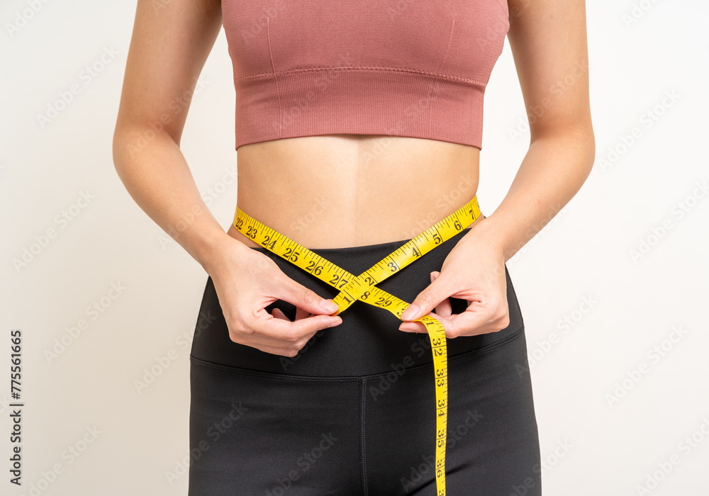 Close up woman measuring her waistline with measure tape. Weight loss ...