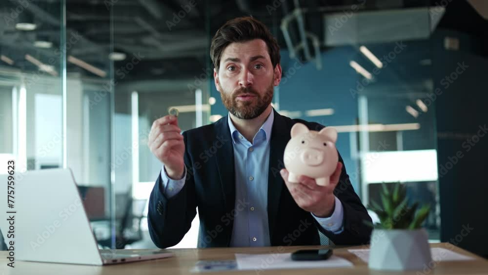 Serious investor holding pink piggybank and metal coin in arms while ...