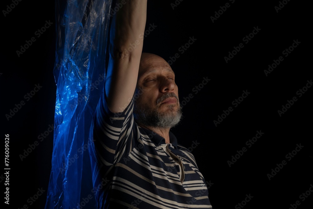 Bald mature man suffocating with a transparent plastic bag flying over ...