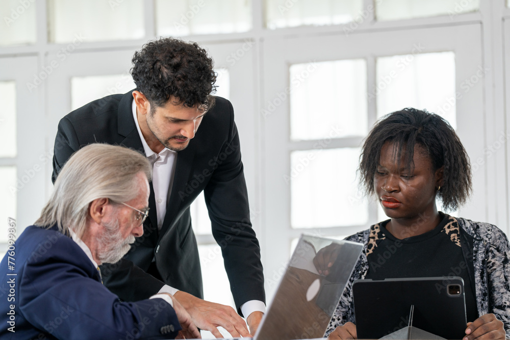 Multigenerational business team engaged in active discussion with a ...