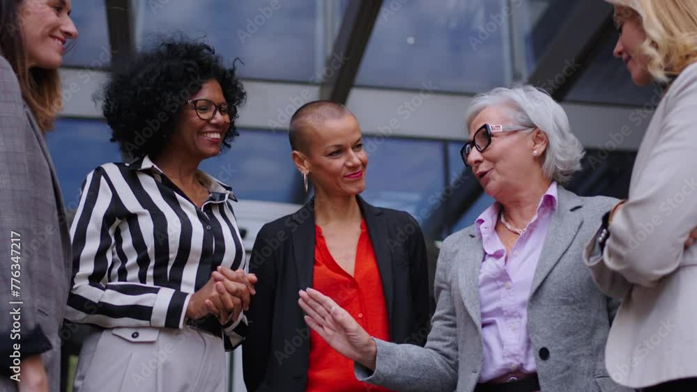 Low angle. Team of cheerful business women of various ages and races ...